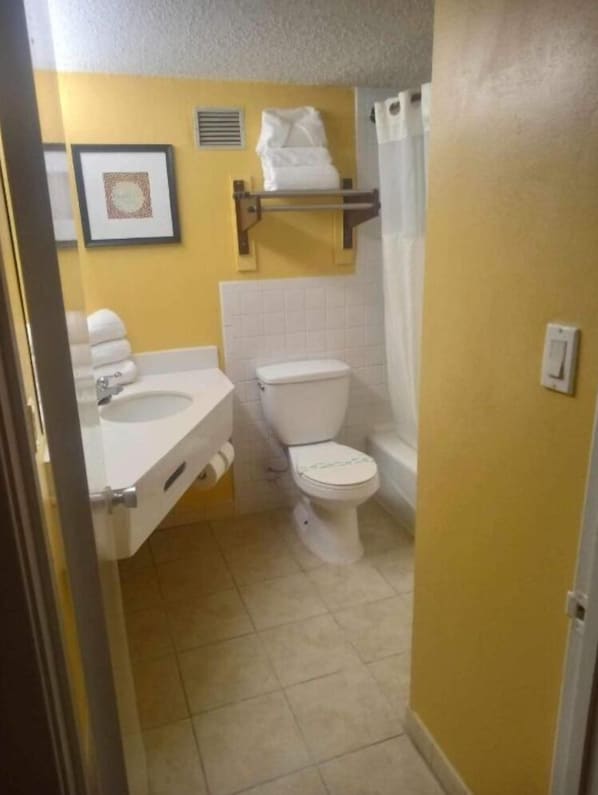 Uma casa de banho pequena com sanita, lavatório e porta-toalhas.