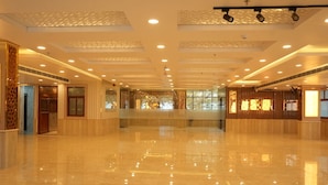 Um hall amplo com piso de mármore polido, iluminação embutida e design moderno no teto.