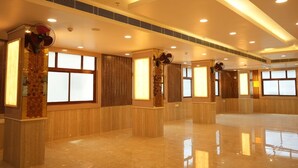 Um amplo saguão de hotel com piso de mármore polido, janelas grandes e pilares decorativos.