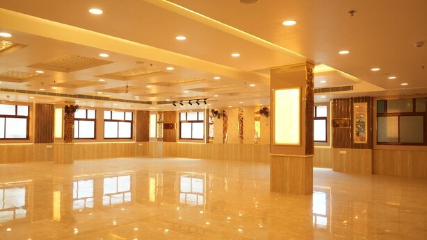 Um hall de hotel espaçoso e bem iluminado, com piso de mármore polido, grandes janelas e design de teto moderno.