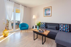 Apartamento, sacada, vista parcial para o mar | Área de estar | TV de tela plana 32 polegadas com canais a cabo