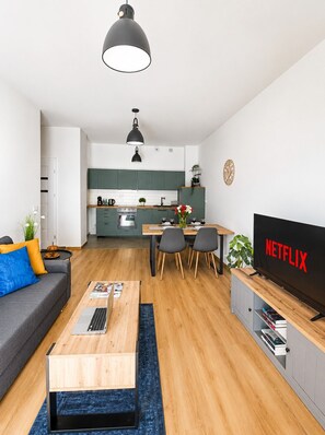 Uma sala de estar moderna com sofá, mesa de centro e televisão.