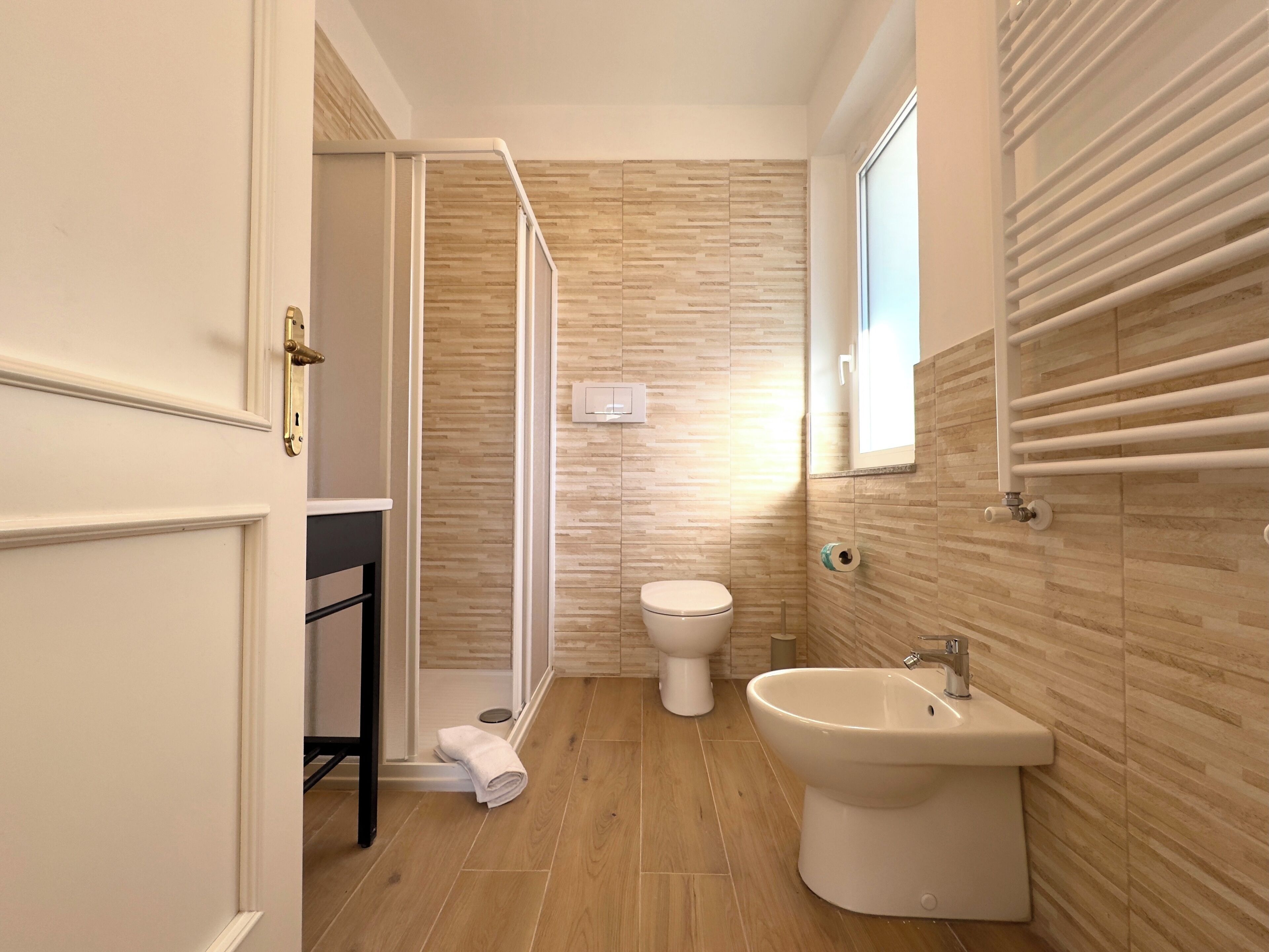 Uma casa de banho moderna com chuveiro, sanita e bidé.