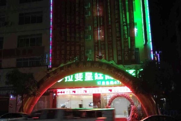 Um edifício com uma grande entrada em arco, iluminado por luzes coloridas.