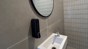 Chuveiro, toalhas de banho, sabonete, shampoo