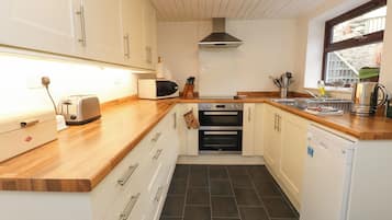 Uma máquina de lavar louça, utensílios de cozinha