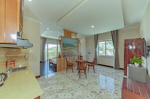 Um quarto espaçoso com área de refeições, cozinha e uma grande janela com vista.