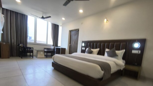Quarto de hotel com uma cama grande, uma escrivaninha e uma cadeira.