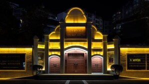 Um edifício com entrada imponente, destacando um grande arco e sinalização iluminada.