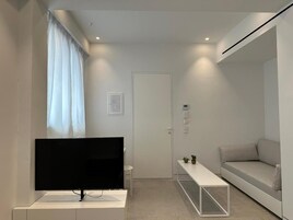 Apartamento, vista para a cidade | Área de estar | TV de tela plana