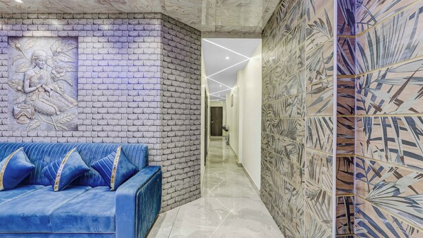 Um interior moderno com um sofá azul, uma parede de tijolos decorativa e um mural ornamental.