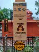 Sinal de prevenção da COVID-19 com orientações sobre o uso de máscaras e distanciamento social.