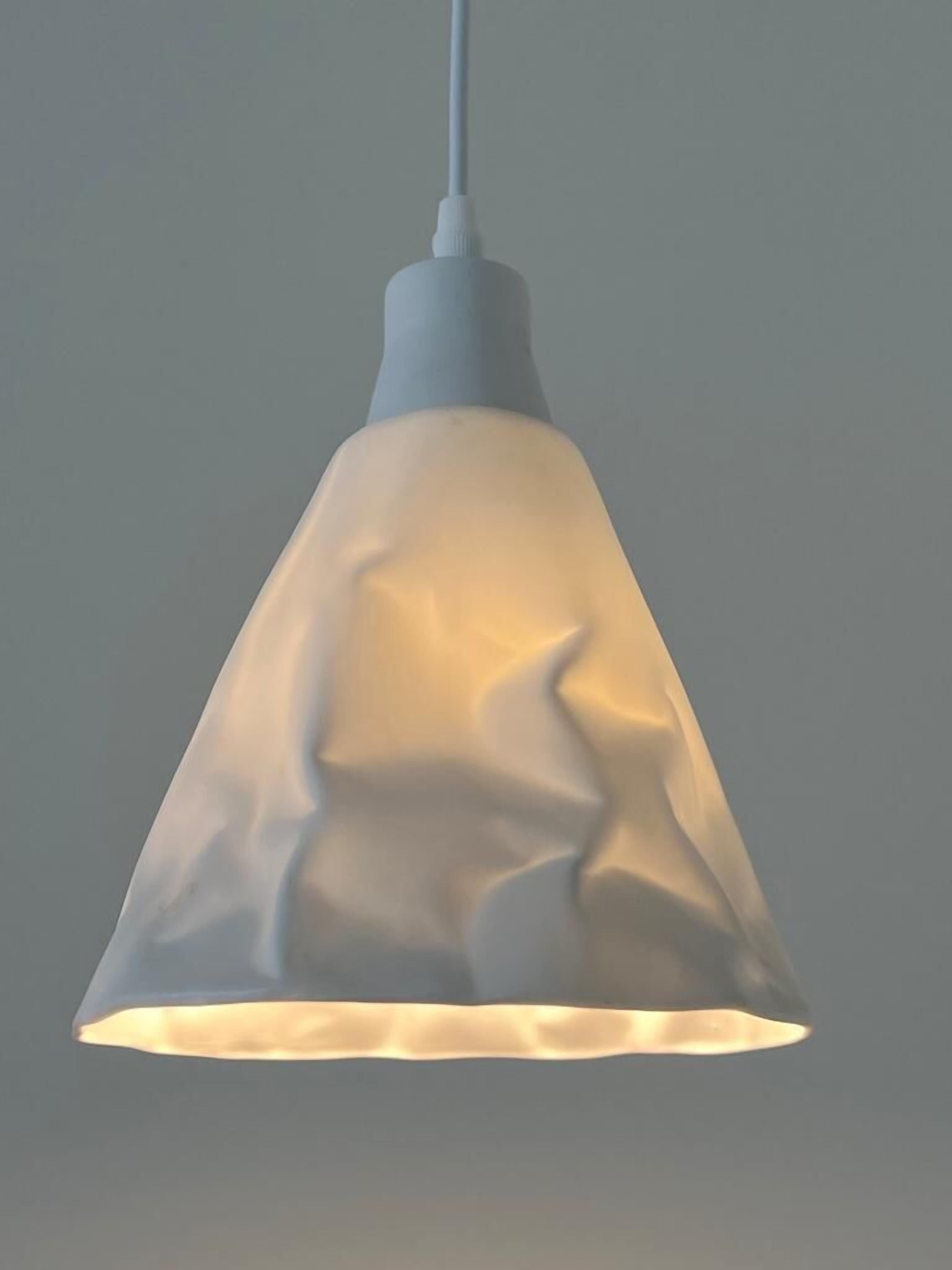 Uma luminária pendente com cúpula de vidro de textura única.