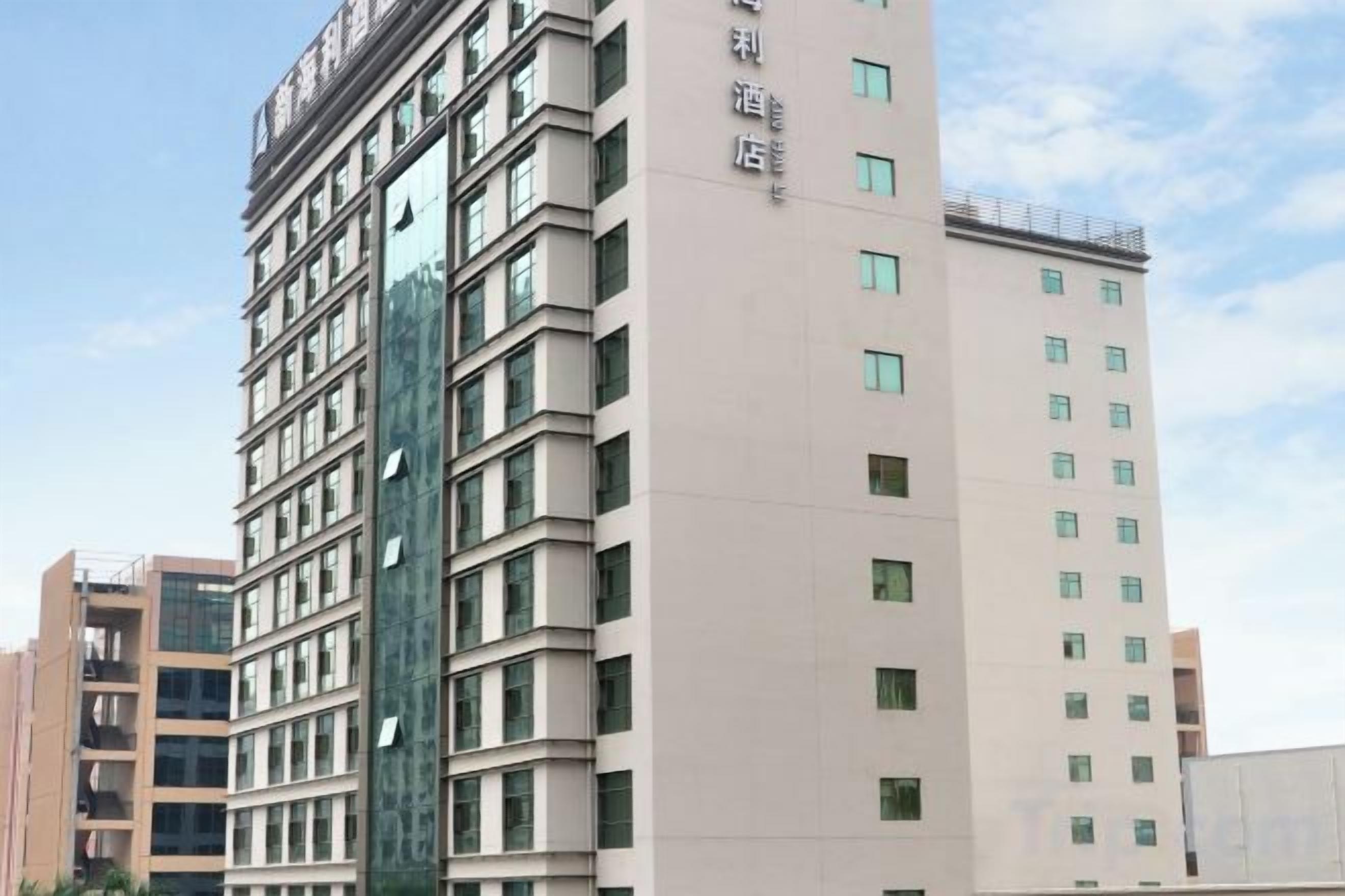 Um edifício de hotel com várias andares e fachada moderna, com vários janelões e varandas.