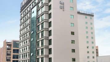 Um edifício de hotel com várias andares e fachada moderna, com vários janelões e varandas.