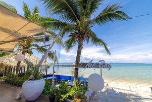 Na praia, praia de areia branca, espreguiçadeiras, guarda-sóis de praia 