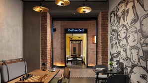 Um café acolhedor com um tabuleiro de xadrez, assentos e um mural.