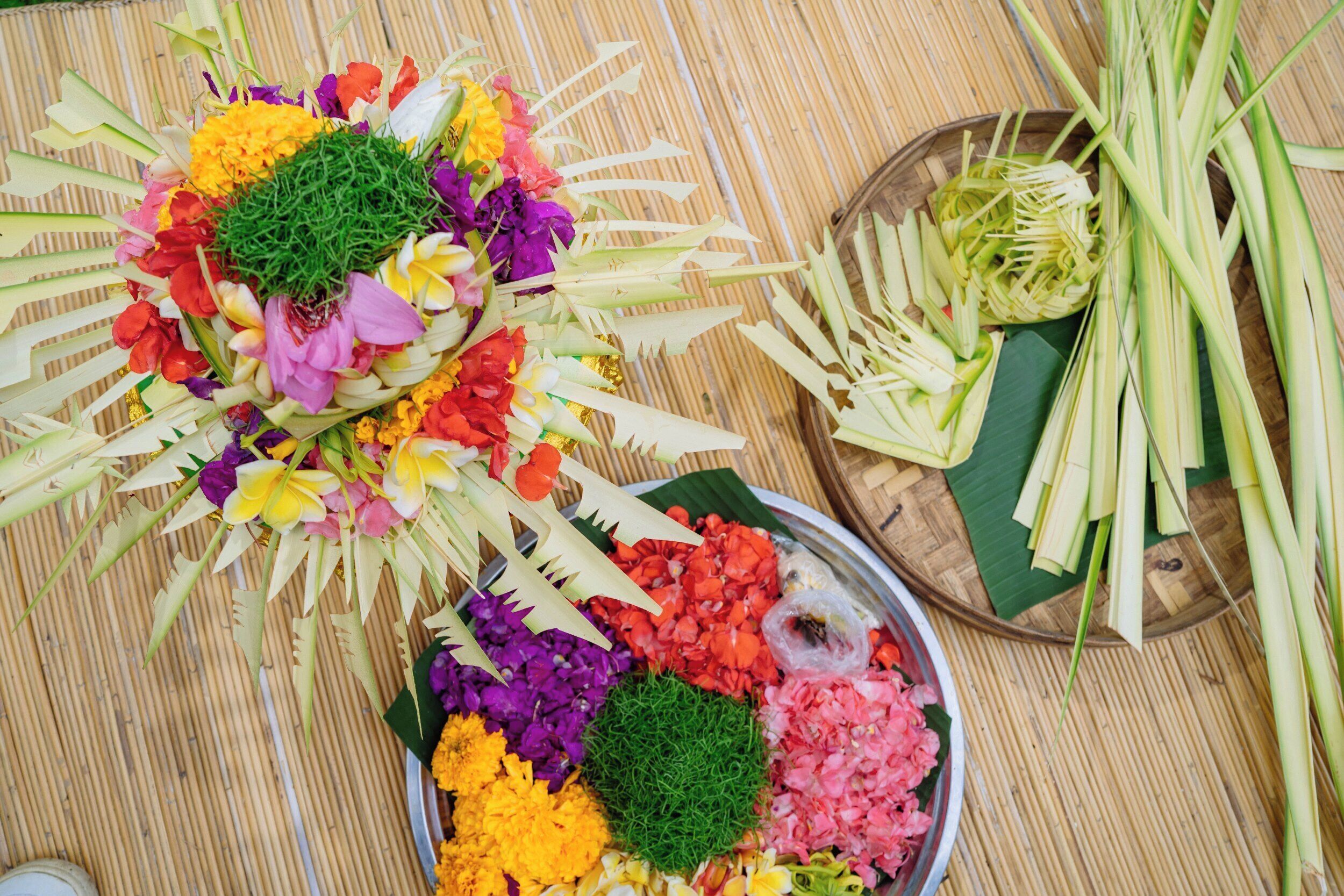 Uma mesa com um suporte de metal contendo diversas flores coloridas e folhas verdes.