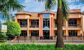 Um hotel com fachada simétrica, várias varandas e entrada central.