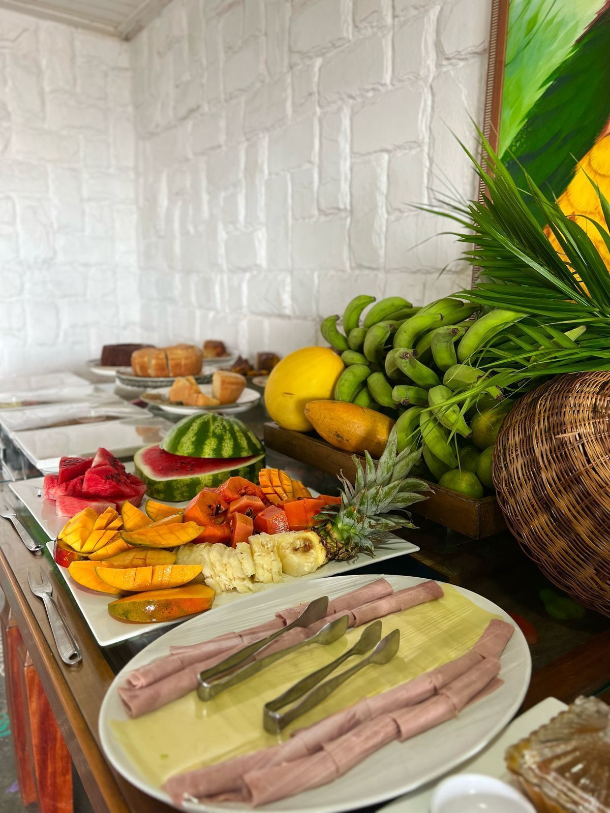Uma mesa de buffet com diversas frutas, legumes e carnes.