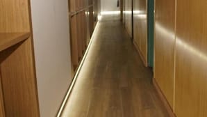Um corredor com lambris de madeira e piso de madeira.
