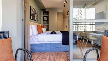 Um quarto com uma cama, uma escrivaninha e cadeiras.
