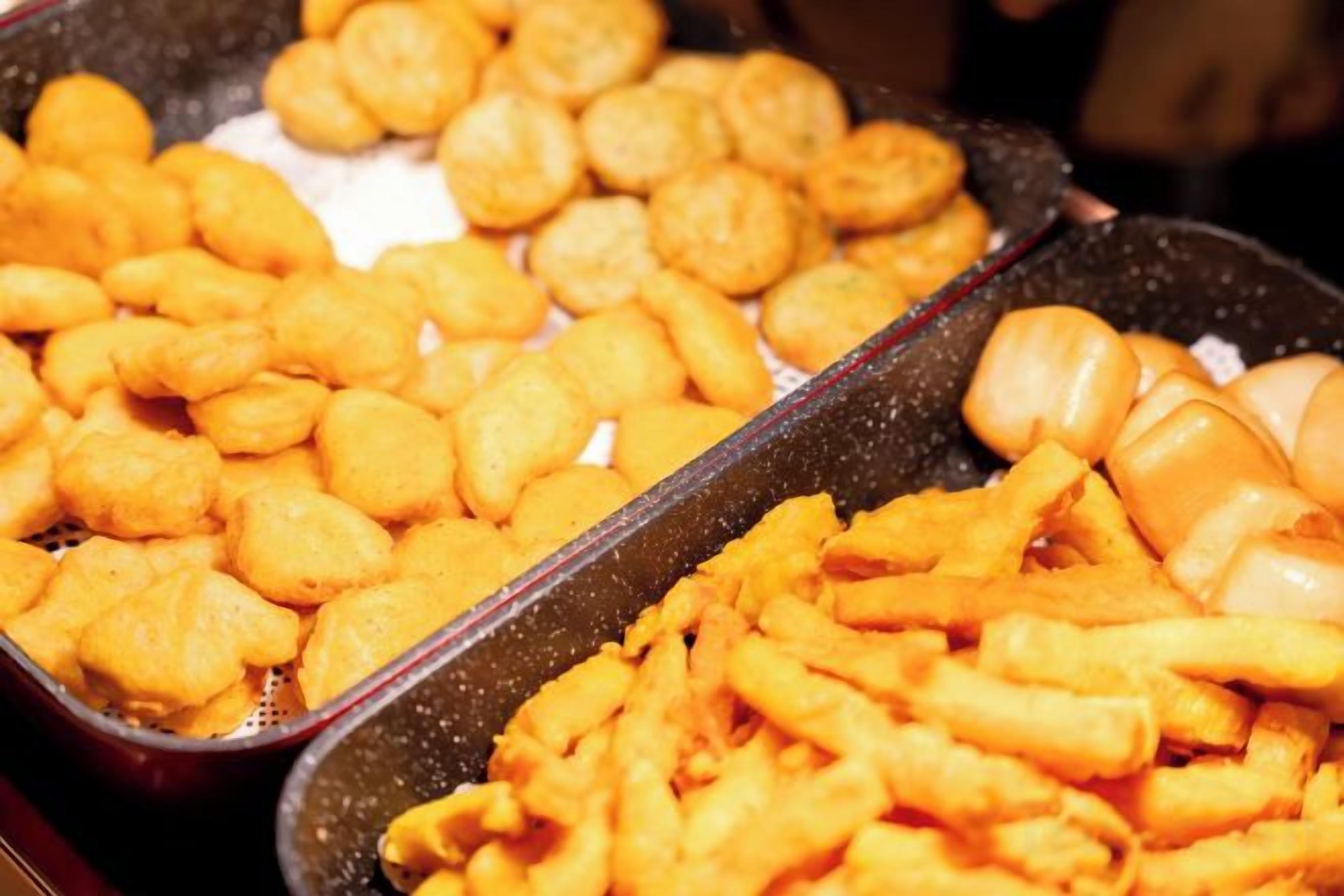 Bandejas com alimentos fritos, provavelmente para um buffet.