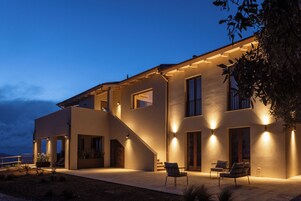 Uma casa moderna com um amplo pátio, escadas e área de estar externa.