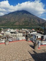 Vista de uma paisagem montanhosa com um corpo d'água em primeiro plano.