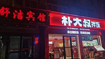 Restaurante com placa vermelha e cardápio à mostra no exterior.