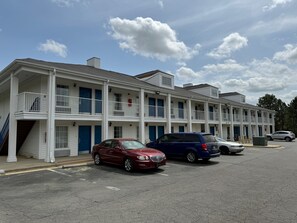 Um motel de vários andares com uma fileira de quartos, cada um com uma varanda.