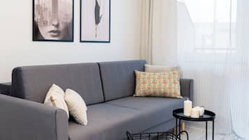 Apartamento conforto, sacada, vista para a cidade | Área de estar | Smart TV 50 polegadas com canais a cabo, Netflix, serviços de streaming