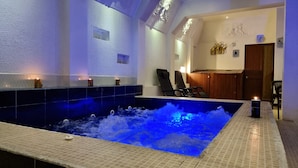 Uma área de spa com hidromassagem, assentos e um armário de madeira.