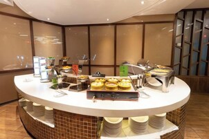Balcão de buffet com diversos alimentos e acompanhamentos.
