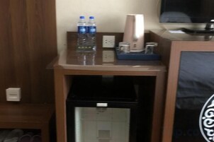 Mini-bar com água engarrafada e máquina de café.
