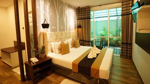 Quarto moderno com uma cama grande, uma mesa de cabeceira com telefone, um criado-mudo, televisão na parede e vista para o exterior por uma grande janela.