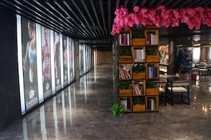 Um corredor com estante, árvore de Natal e piso lustroso.