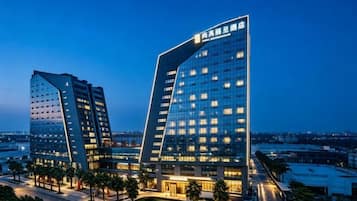 Um hotel moderno com design arquitetônico marcante, destacando uma fachada curva proeminente e vários andares.