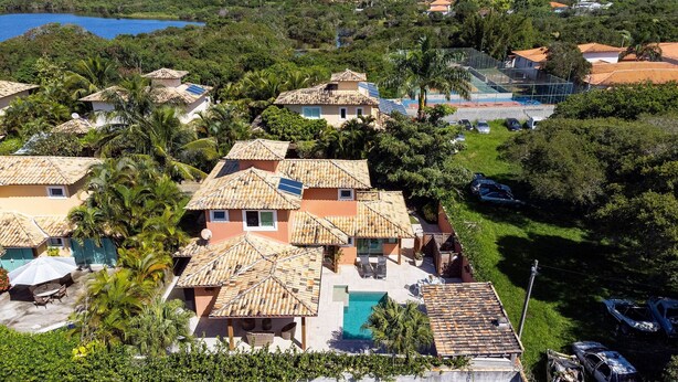 Um bairro residencial com casas de telhado apaleçado, uma piscina e uma quadra de tênis.