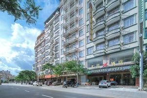 Hotel com vários andares, restaurante no térreo e placa de identificação visível.