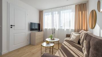 Apartamento superior, vista para a cidade | Área de estar | Smart TV 42 polegadas com canais a cabo, Netflix, serviços de streaming