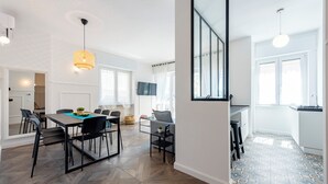 Um interior moderno com área de jantar, cozinha e escada.