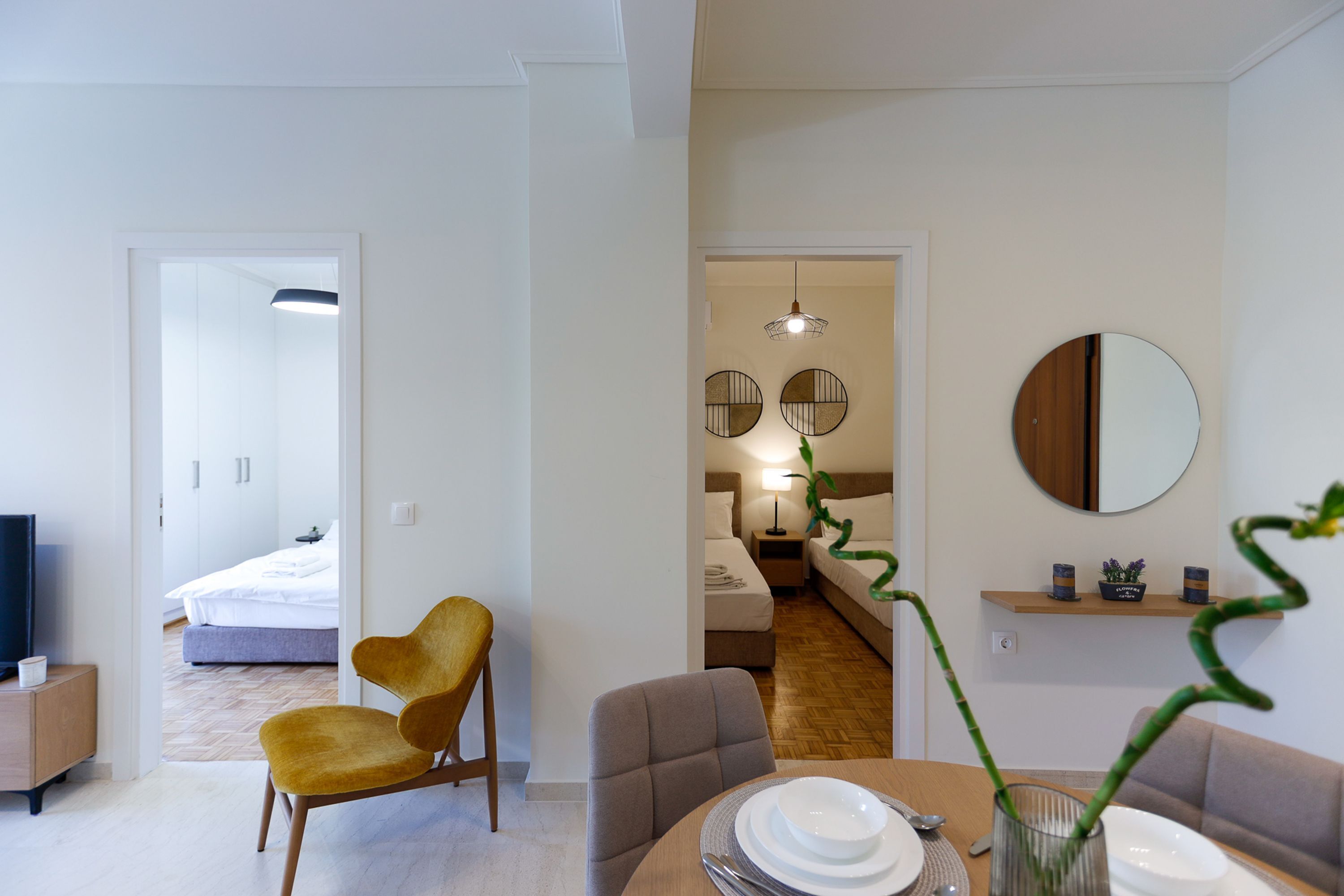 Quarto de hotel moderno com área de jantar, uma cama e um banheiro visível por uma porta aberta.