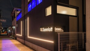 Entrada de hotel moderna com sinalização iluminada e grade de metal.
