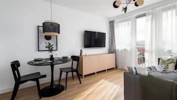 Apartamento conforto, vista para a cidade | Área de estar | Smart TV 50 polegadas com canais a cabo, Netflix, serviços de streaming