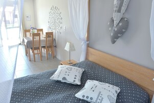 Quarto bem arrumado com cama, almofadas, mesa de cabeceira e abajur.