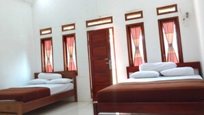 Quarto com duas camas de madeira, cada uma com roupa de cama branca e cortinas vermelhas. Há duas janelas com molduras de madeira e cortinas vermelhas.