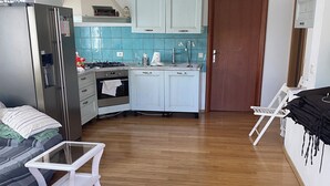 Um espaço compacto com cozinha compacta, área de jantar e quarto.