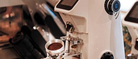 Uma máquina de café com visor digital, moedor e porta-filtro.