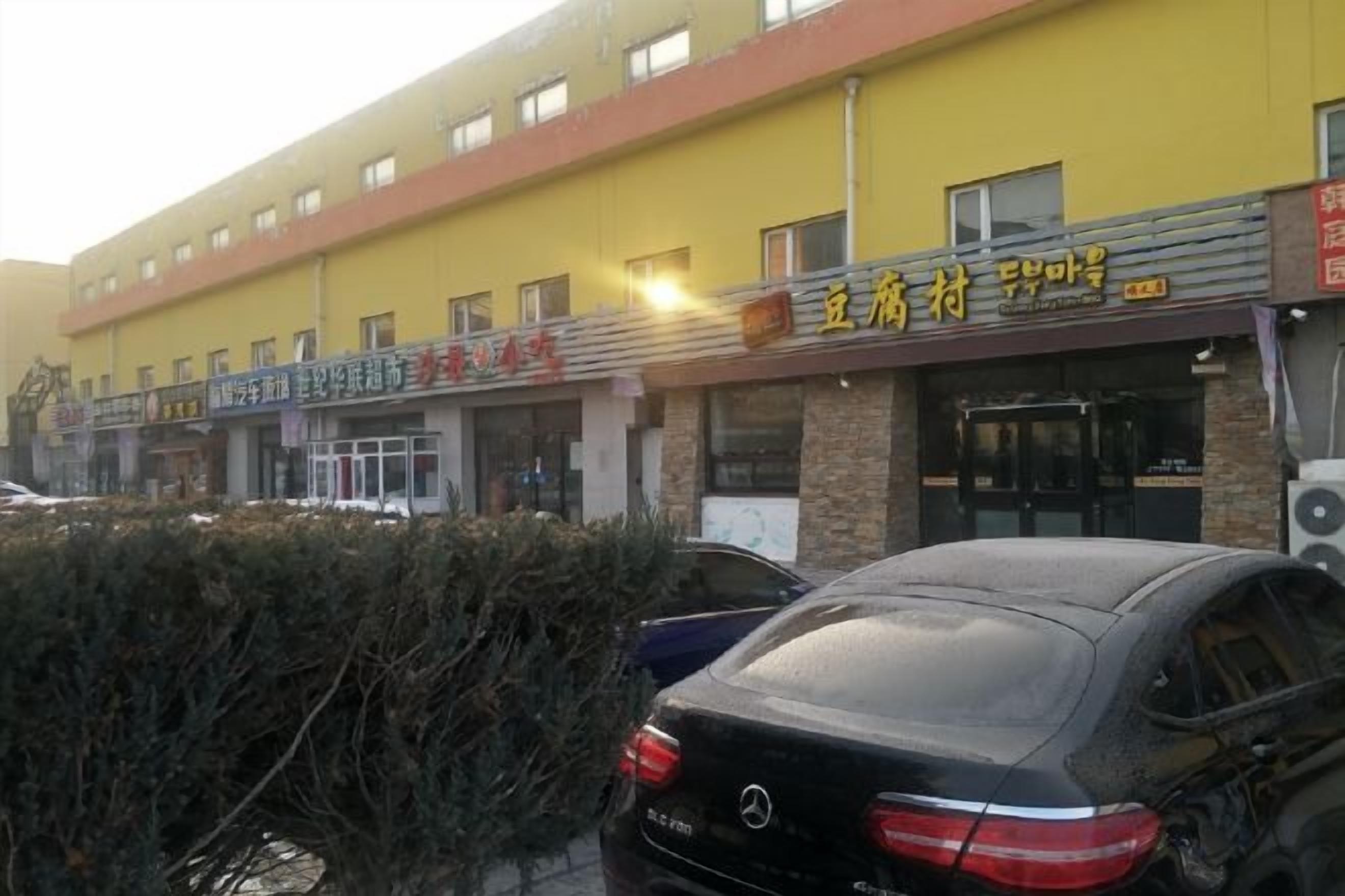 Um edifício com várias lojas, incluindo um restaurante com uma placa em língua estrangeira.